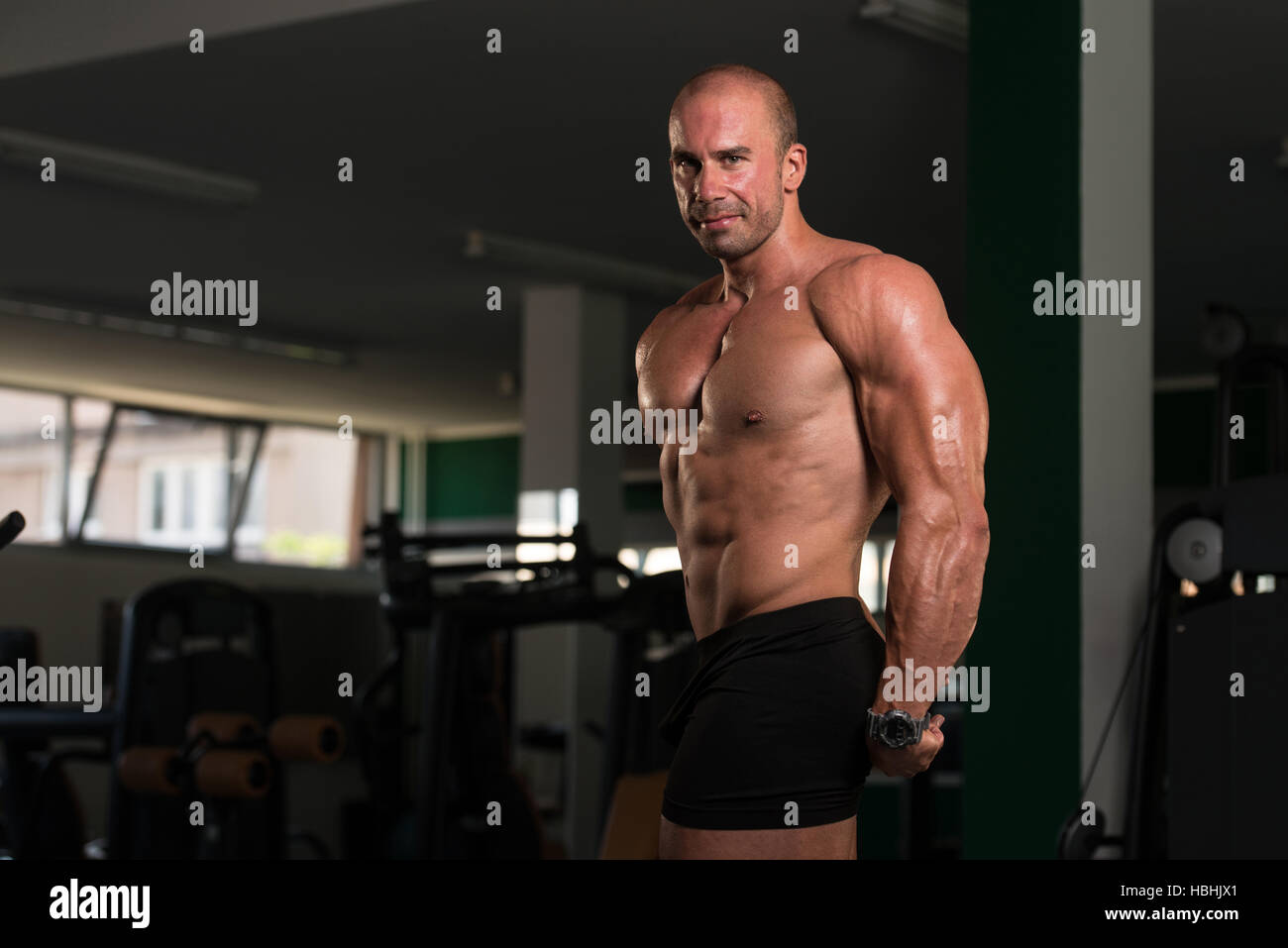 Bald Man Standing Strong In The Gym And Flexing Muscles - Muscular ...