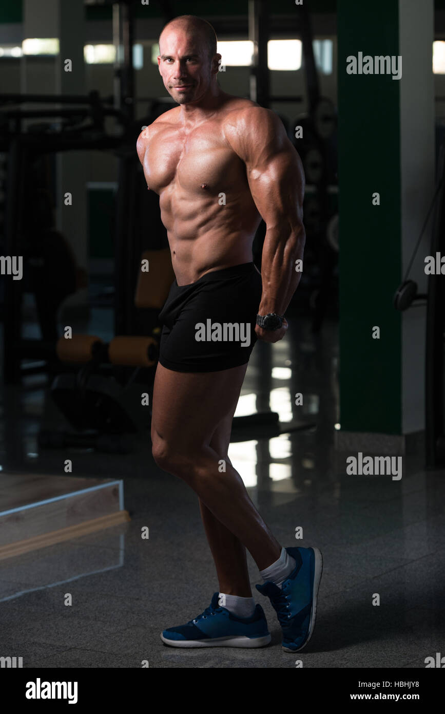 Bald Man Standing Strong In The Gym And Flexing Muscles - Muscular ...
