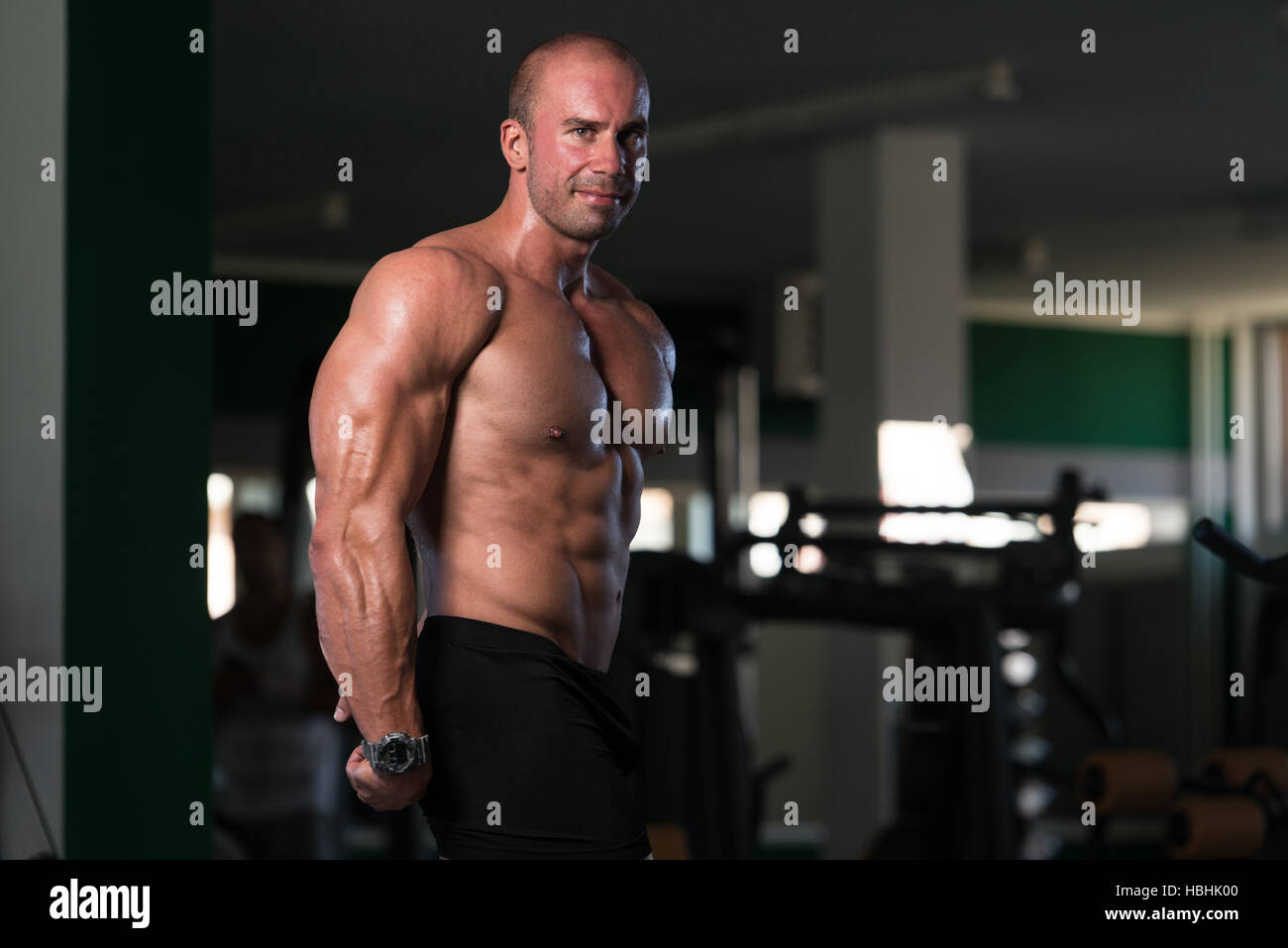 Bald Man Standing Strong In The Gym And Flexing Muscles - Muscular ...