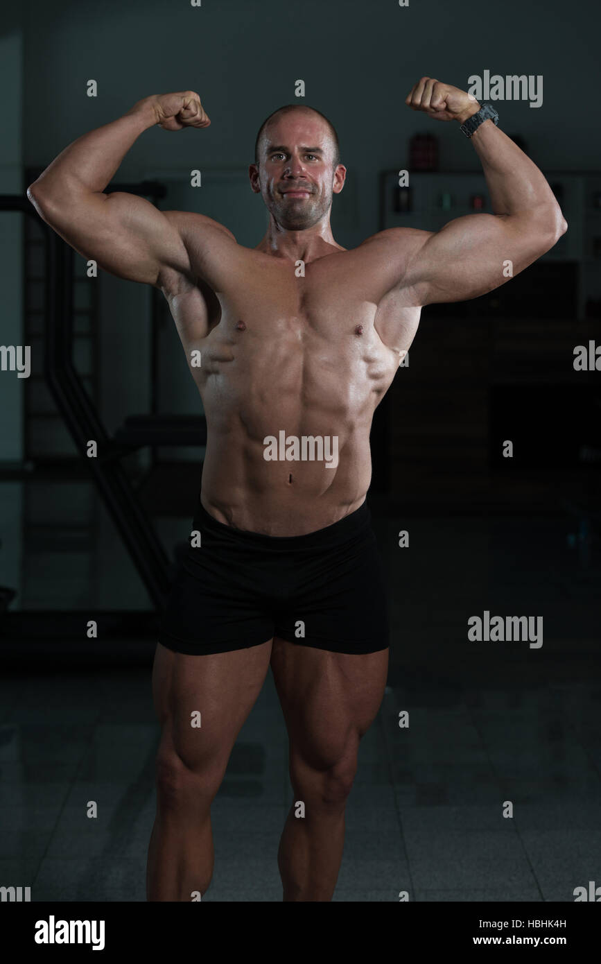 Bald Man Standing Strong In The Gym And Flexing Muscles - Muscular ...