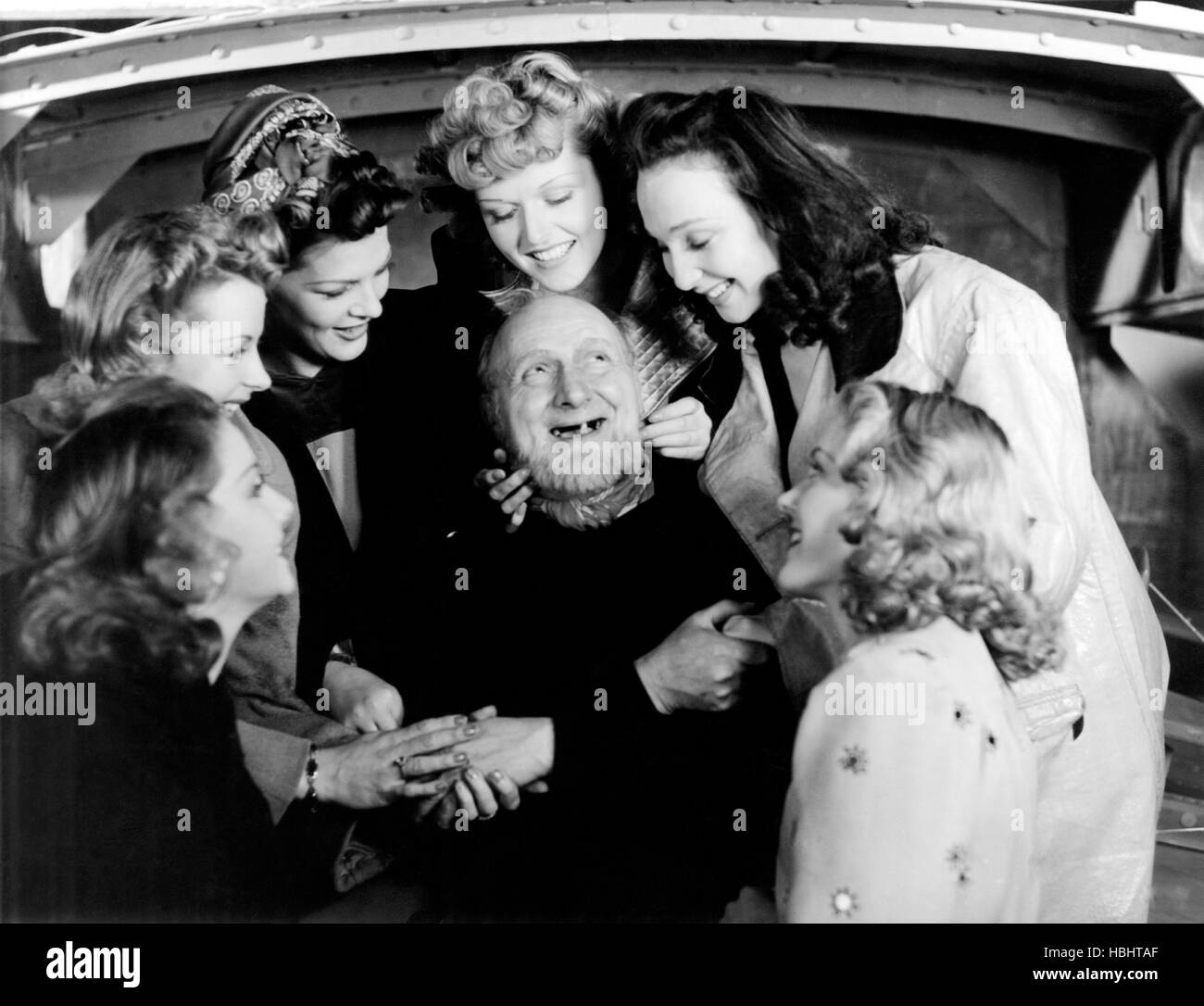 BACK-ROOM BOY, Moore Marriott, surrounded by, from left, Mia Macklin ...