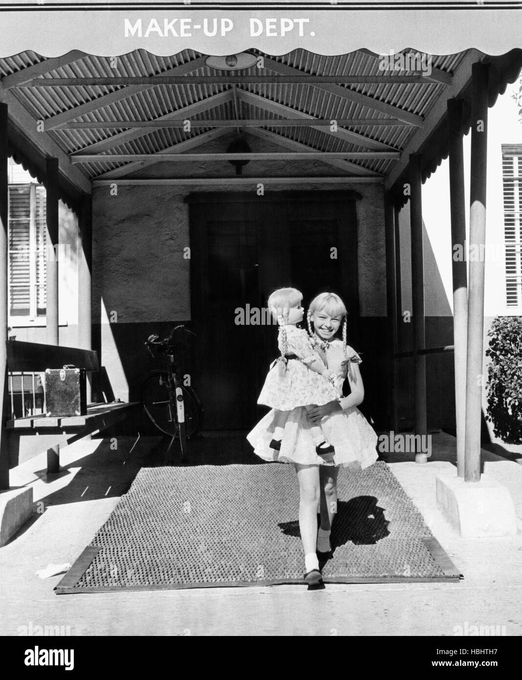 THE BAD SEED, Patty McCormack, with her doll, leaving the Warner ...