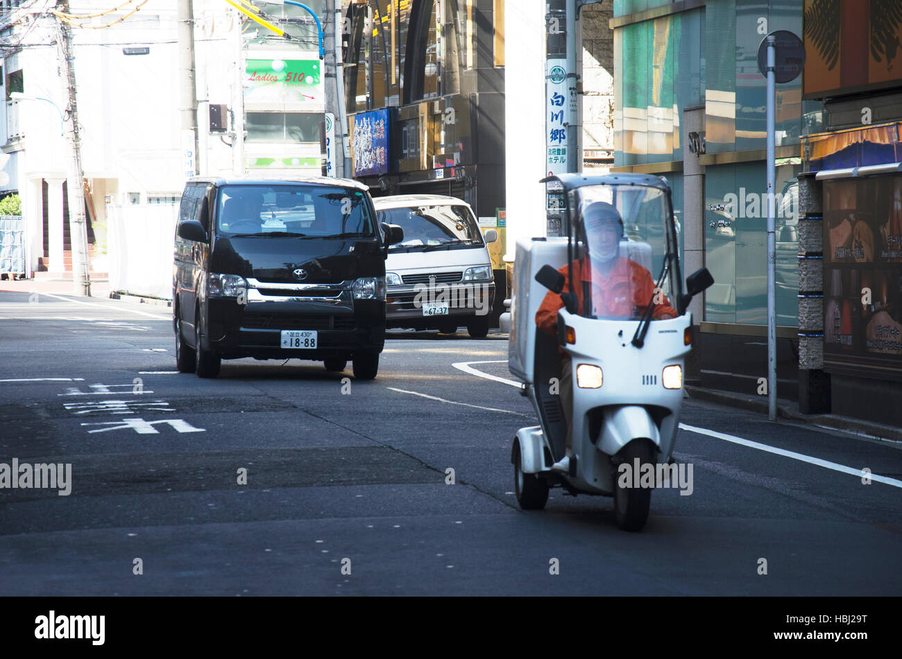 Japanese people driving car and riding motorcycle on the road in small ...