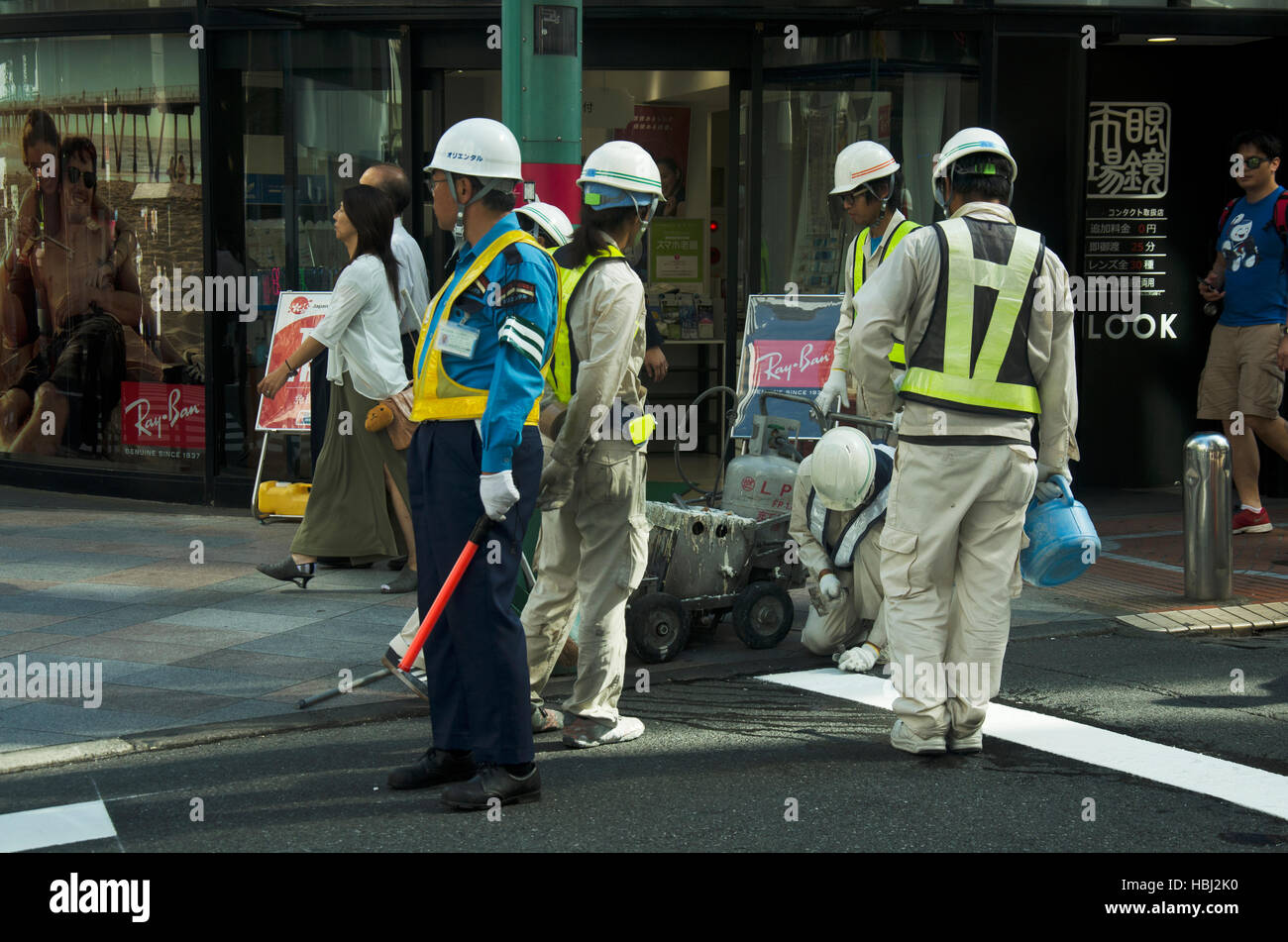 Japanese people in construction site working and repair surface of road ...