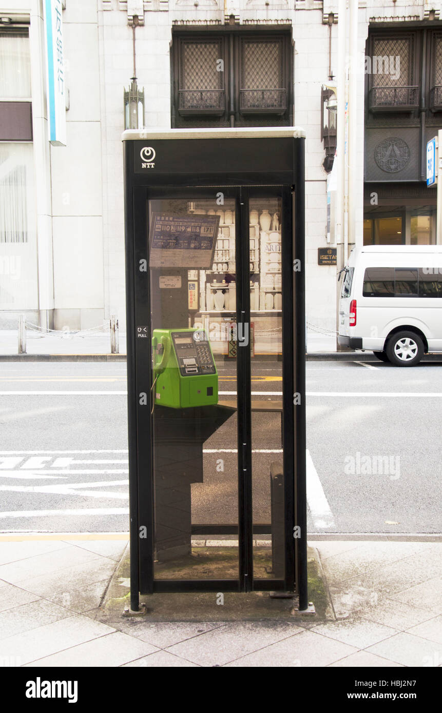 Public telephone on pathway beside traffic road for people use phone at ...