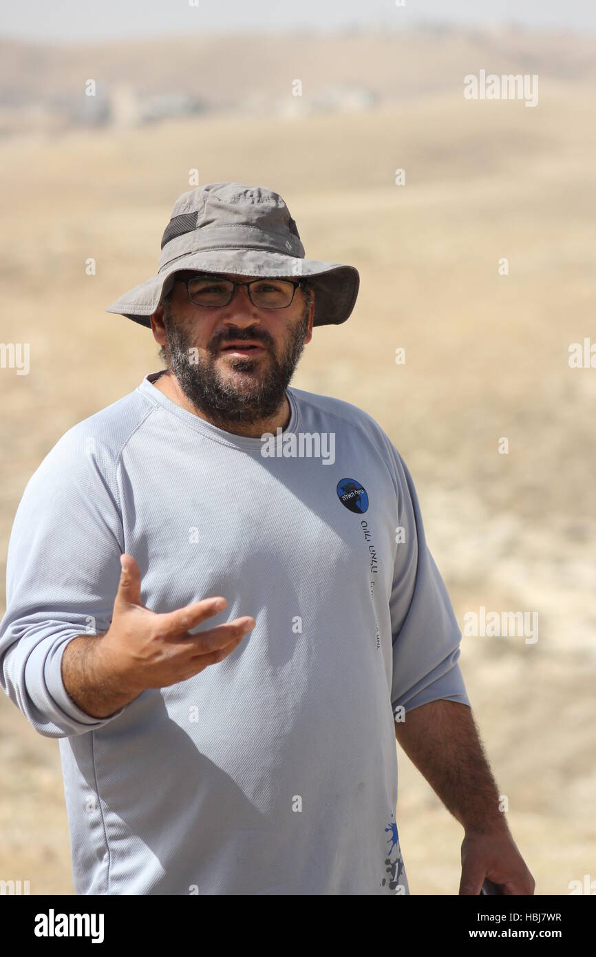 An Israeli tour guide teaches a tourist group in the heat of the Ein ...