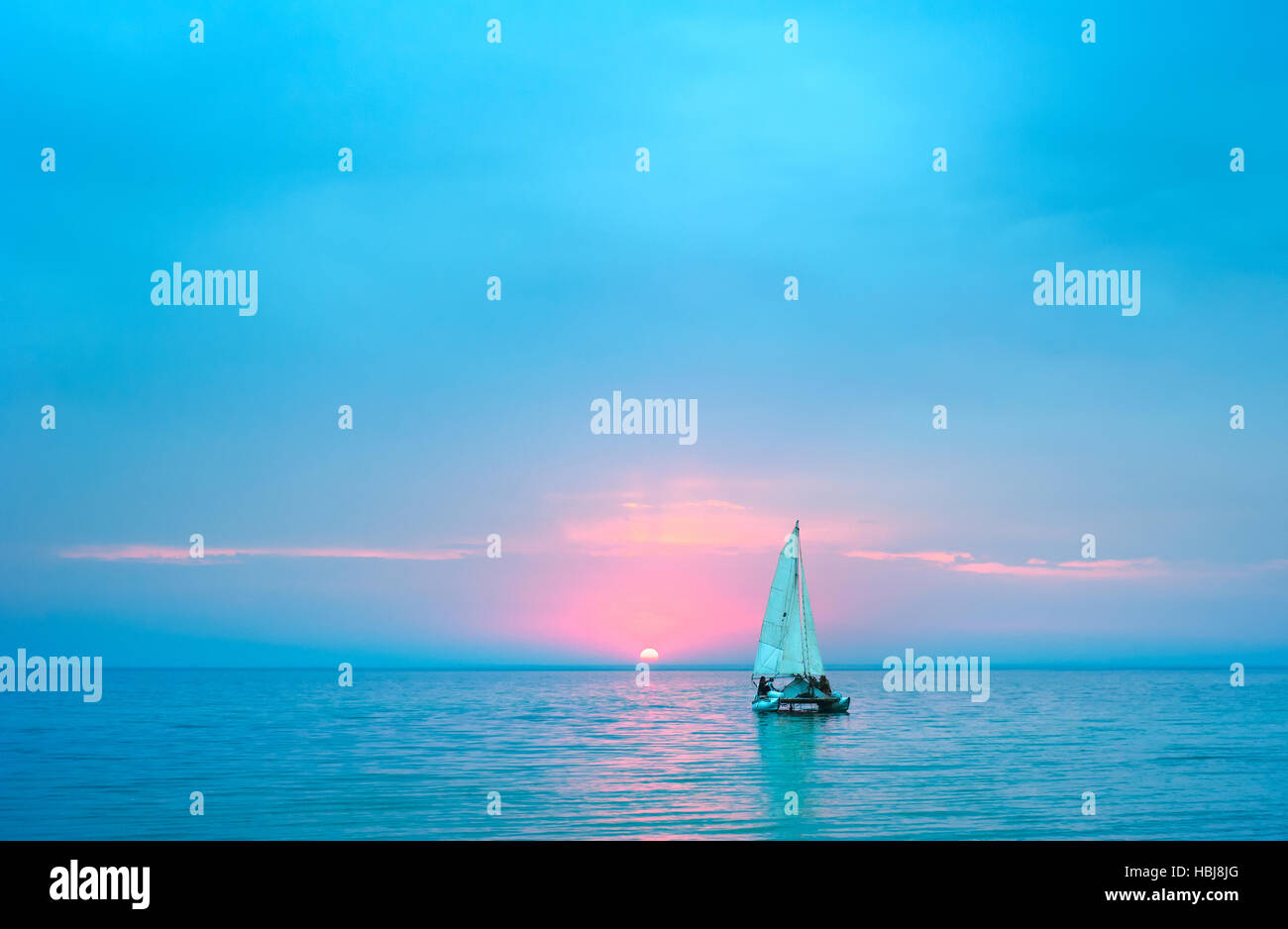 Sailboat at sunset Stock Photo - Alamy
