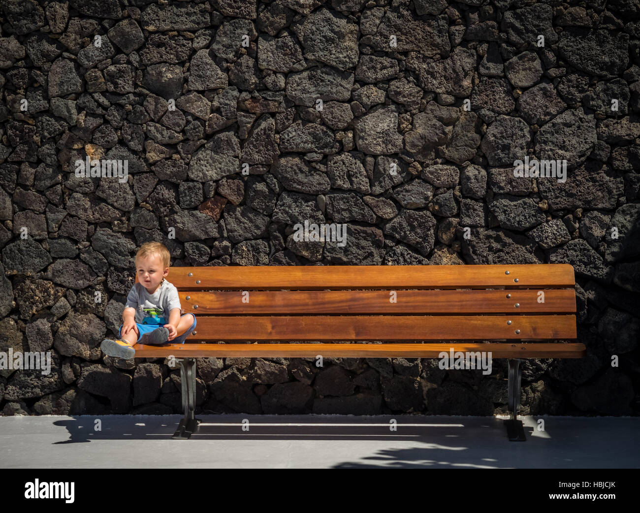 Small boy resting on a bench Stock Photo - Alamy