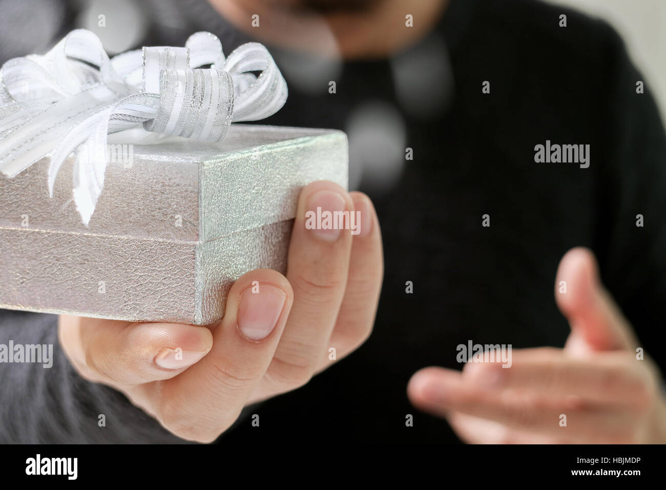 gift giving,man hand holding a gift box in a gesture of giving.blurred ...