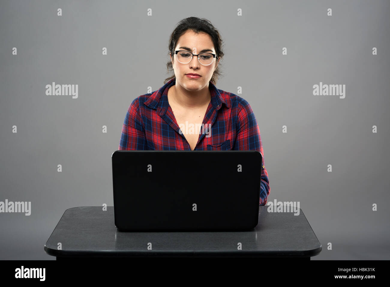 Young hispanic businesswoman sitting at her desk with her laptop Stock ...