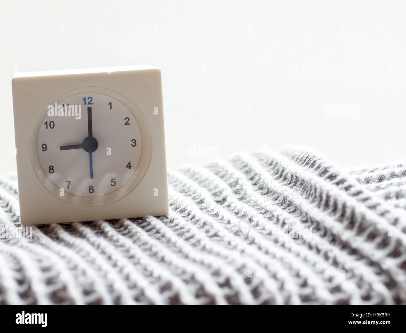 The series of a simple white analog clock on the blanket that depicts ...