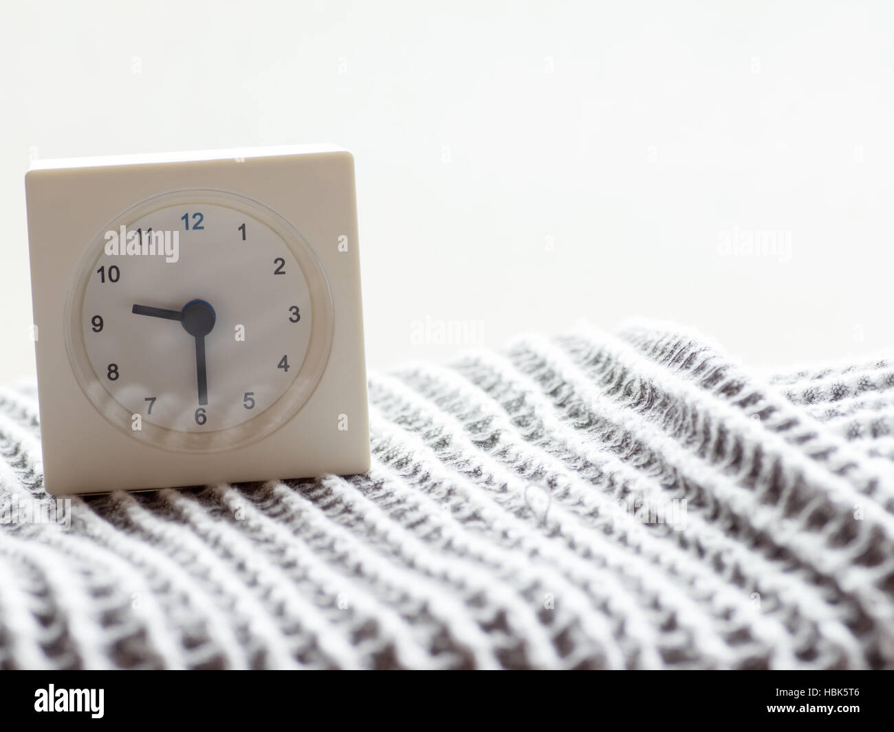 The series of a simple white analog clock on the blanket that depicts ...