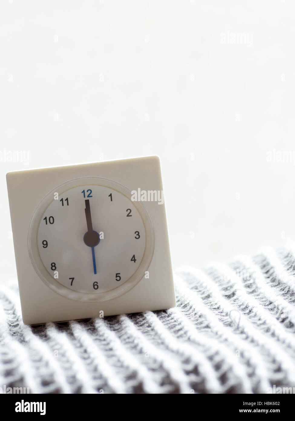 The series of a simple white analog clock on the blanket that depicts ...