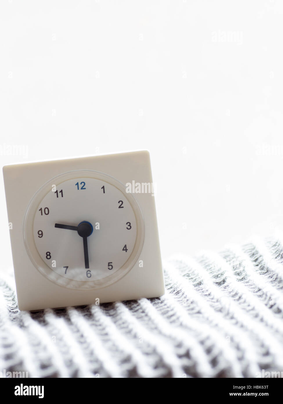 The series of a simple white analog clock on the blanket that depicts ...