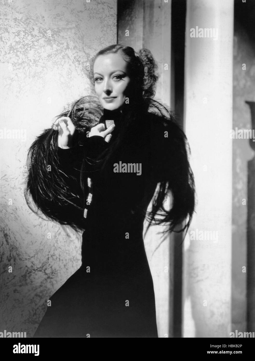 CHAINED, Joan Crawford, in a suit trimmed with jeweled buttons and ...