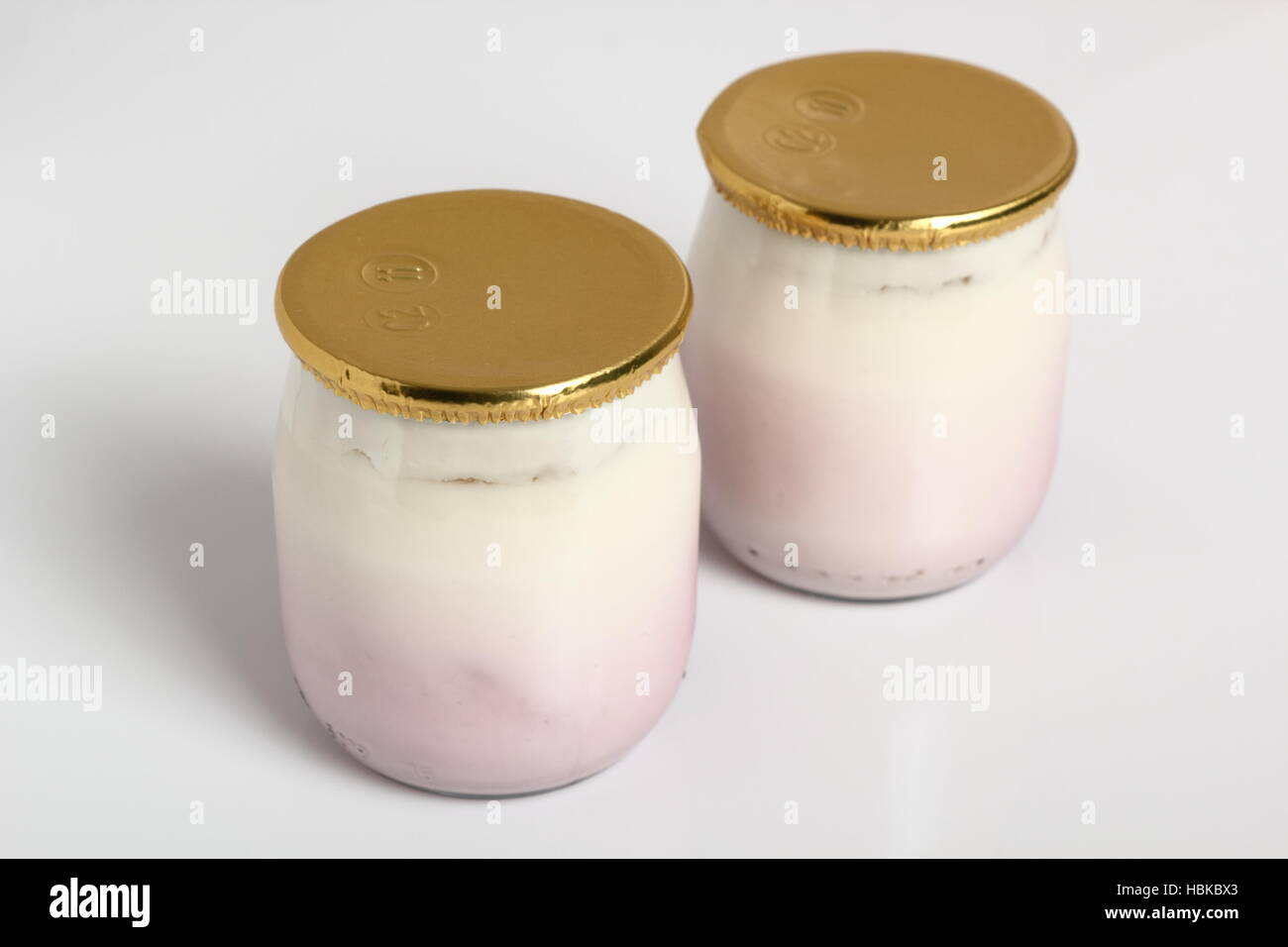 Yogurt in small glass jar with aluminum foil seal cap. Isolated on a ...