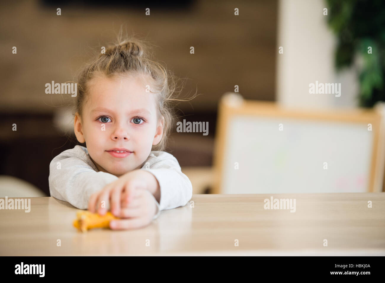 Thoughtful portrait of little girl lay on the table Stock Photo - Alamy