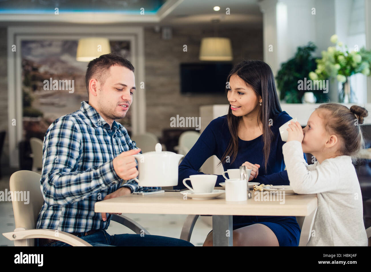 Family Enjoying tea In Cafe Together Stock Photo - Alamy