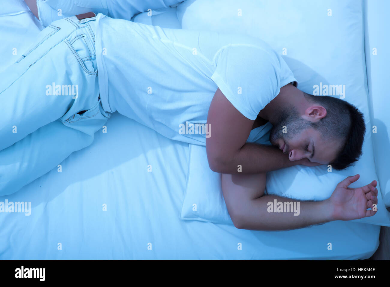 Young man laying in bed at night Stock Photo - Alamy