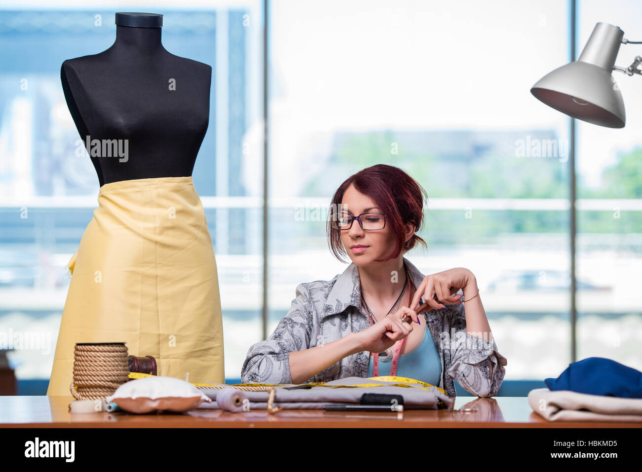 Woman tailor working at her desk Stock Photo - Alamy