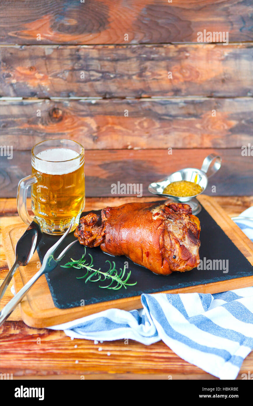 Roasted pork leg (rulka) served with garlic sauce and beer on the ...