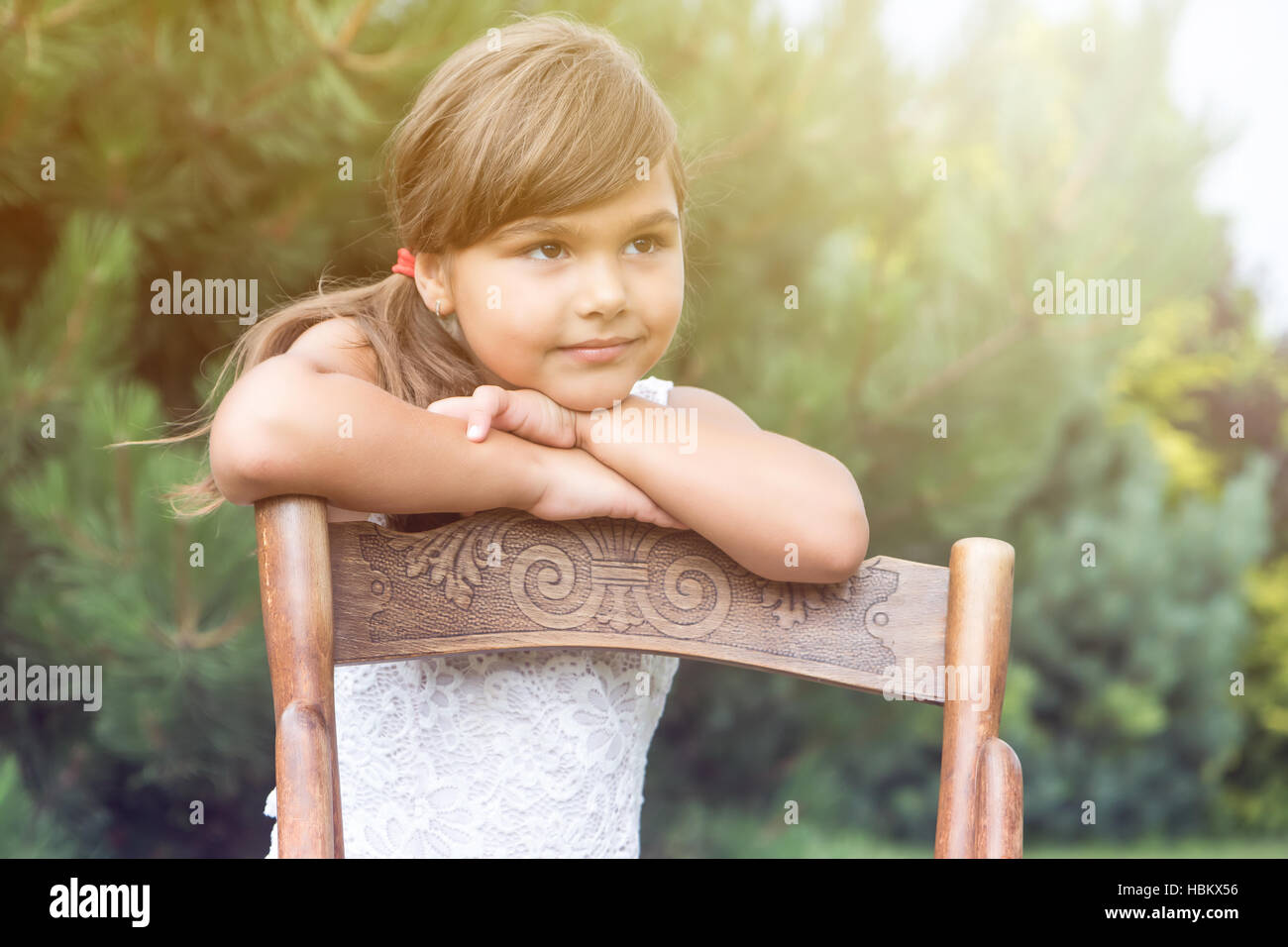 Portrait of long haired brunette little girl leaning on an vintage ...