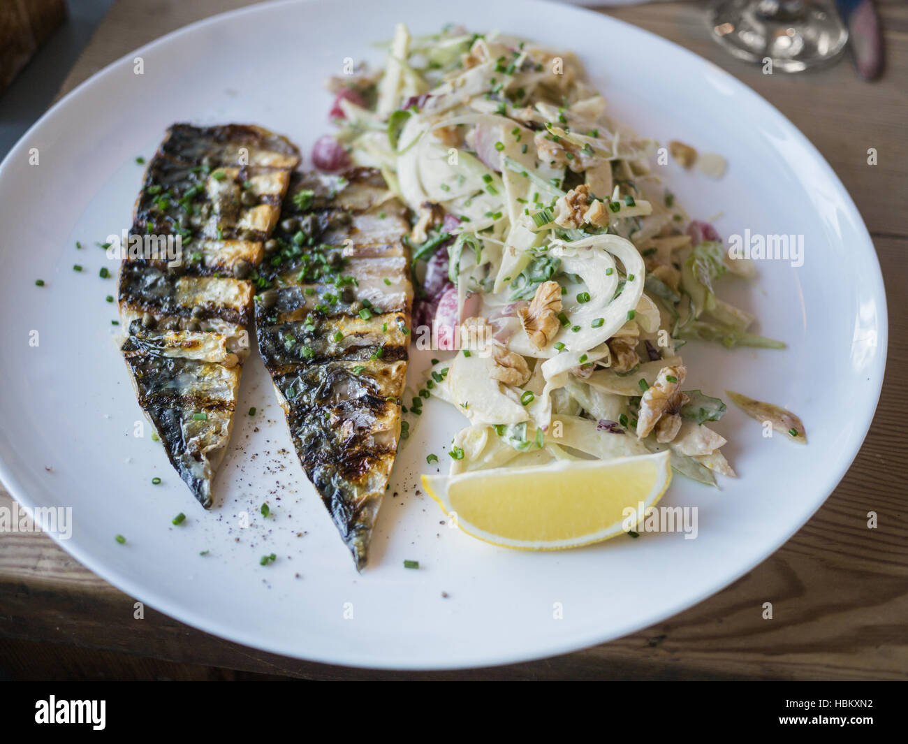 Mackerel fish fillets served with a salad with apple and walnuts. On a ...