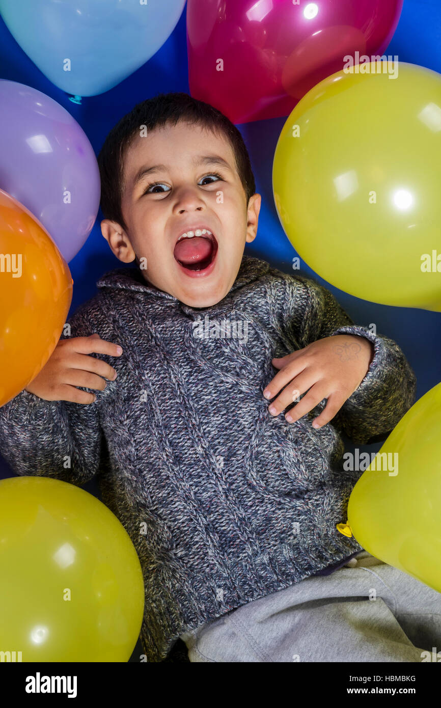 cute child playing with colored balloons at a birthday party happy ...