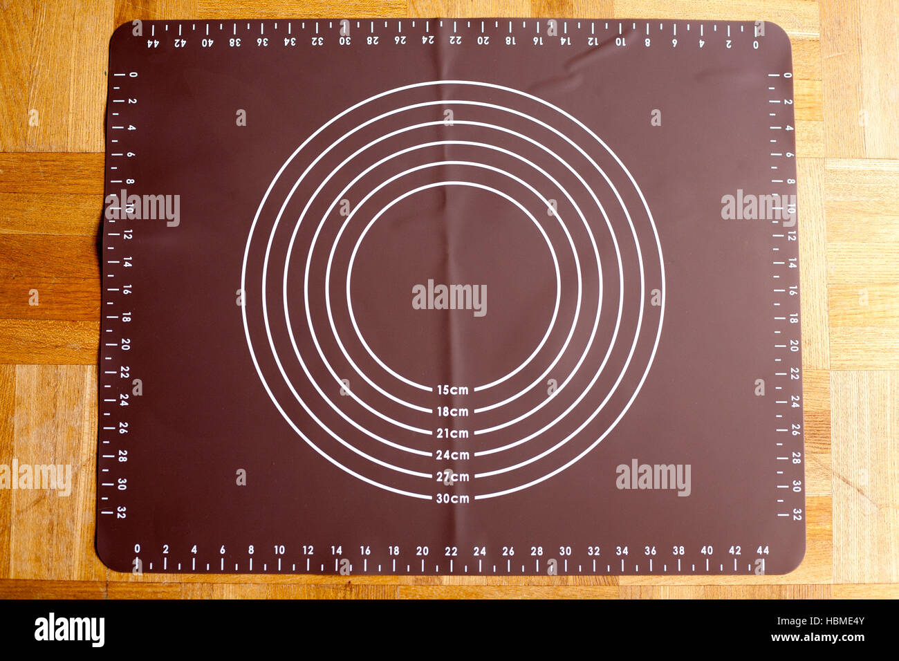 Clean silicon mat with scale marks for kneading dough on wooden table ...