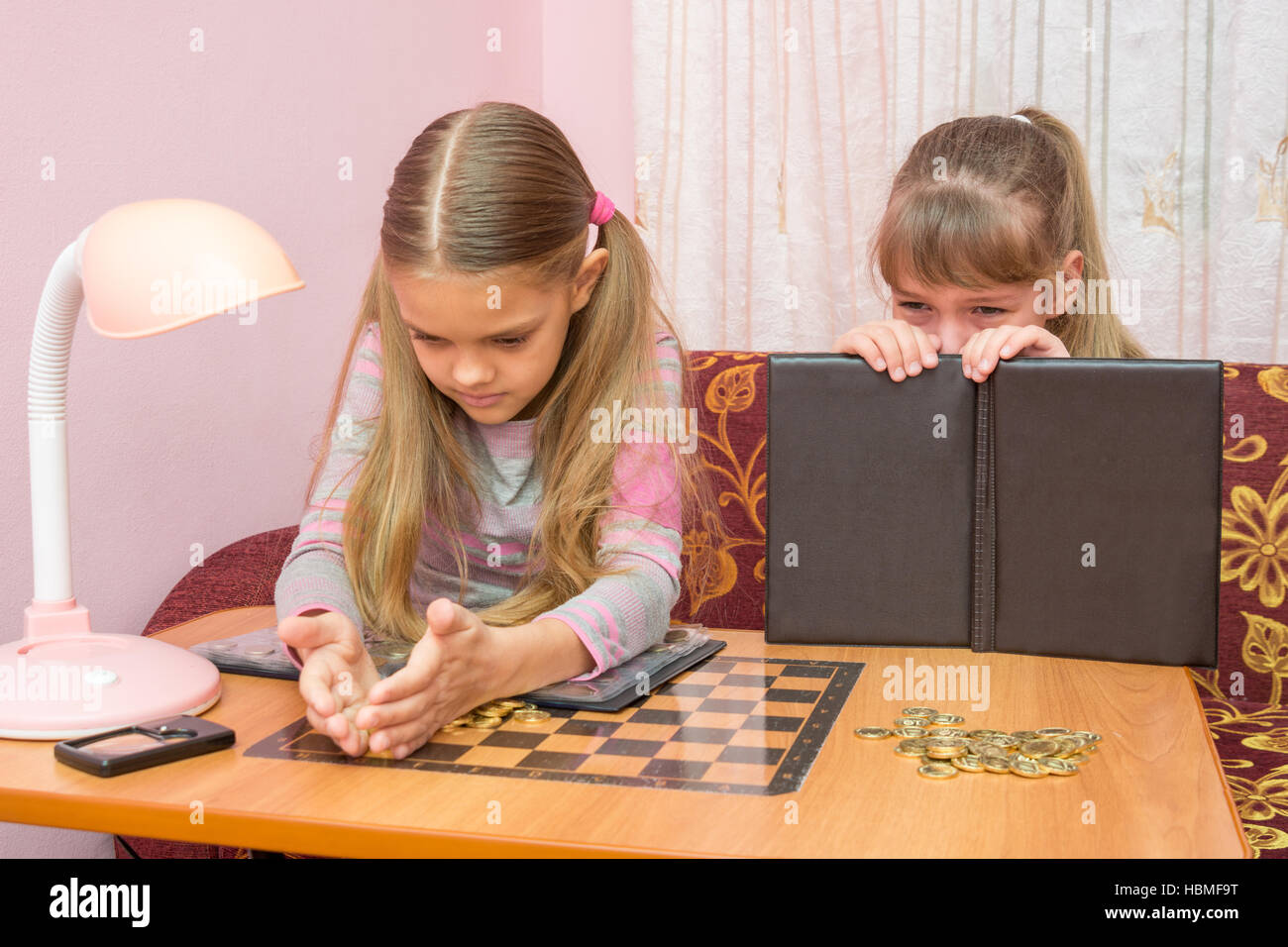 The sisters do not share the coin Stock Photo - Alamy