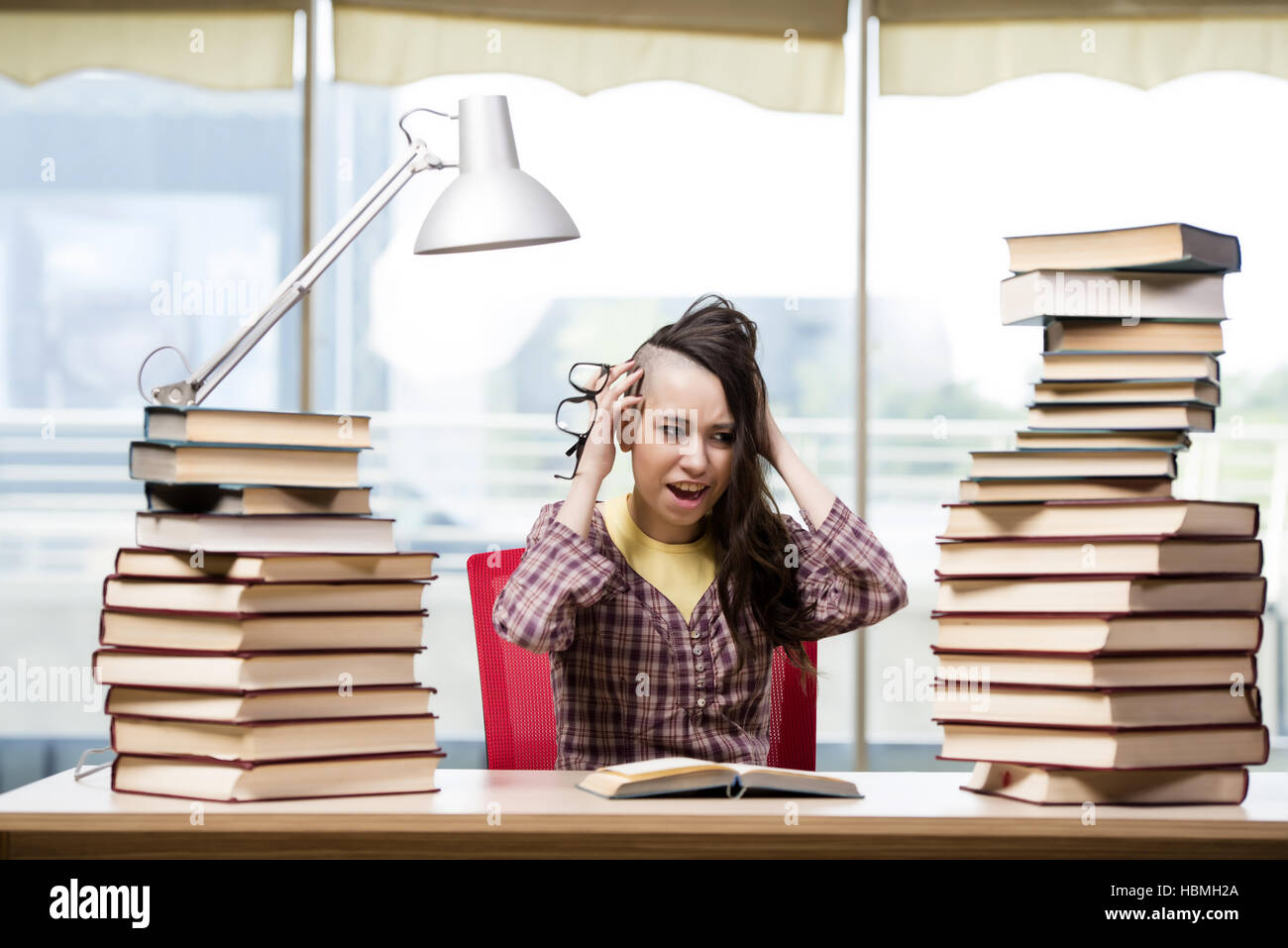 Young student with stack of books Stock Photo - Alamy