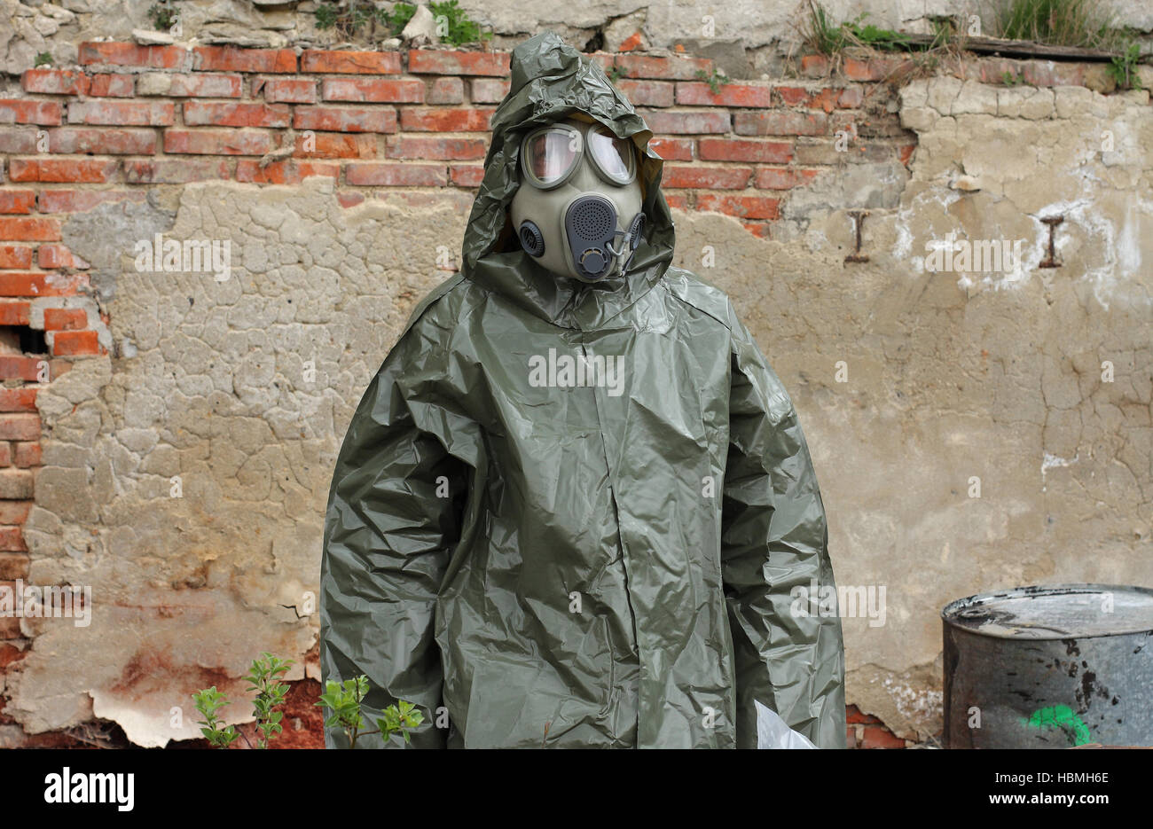 Man with gas mask and green military clothes explores small plant after ...