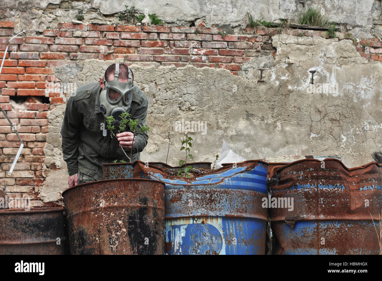 Man with gas mask and green military clothes explores small plant after ...