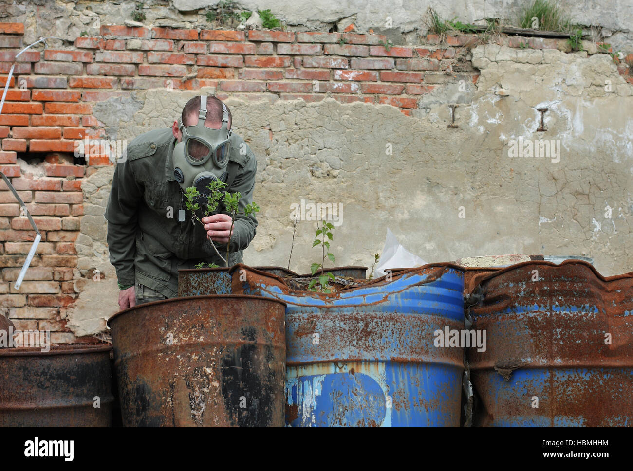 Man with gas mask and green military clothes explores small plant after ...