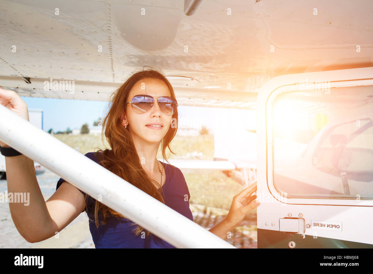 Young smiling woman standing near private plane ready for flight Stock ...