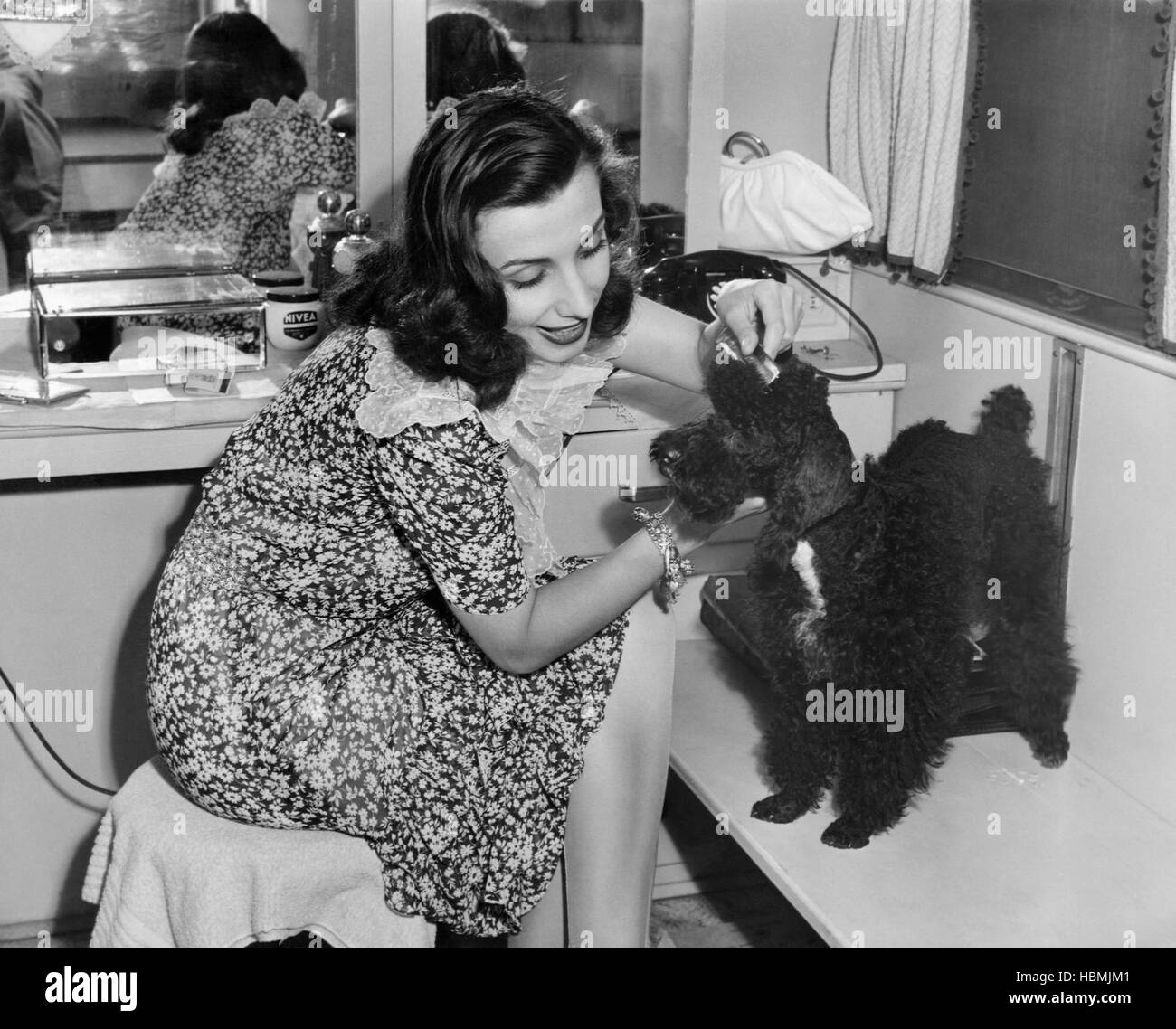 DAYS OF GLORY, Tamara Toumanova, grooming her French poodle, Bela, on ...