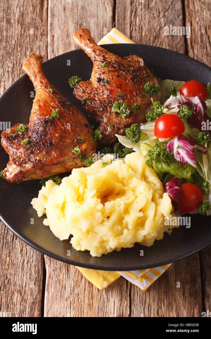 roasted duck leg with mashed potatoes garnish and salad mix close-up on ...