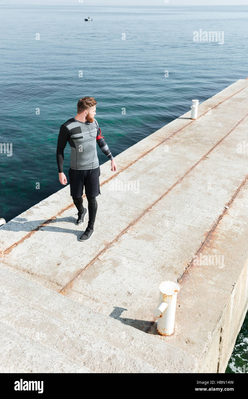 Runner looks back near the sea. full length. from above image Stock ...