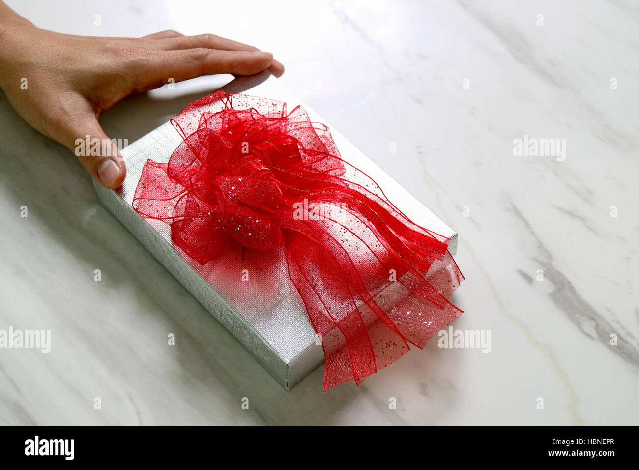 man hand holding a gift box in a gesture of giving.blurred background ...