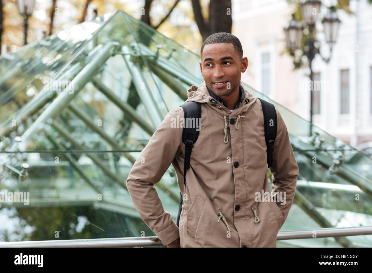 Portrait of a happy african young man walking on the street. Looking ...