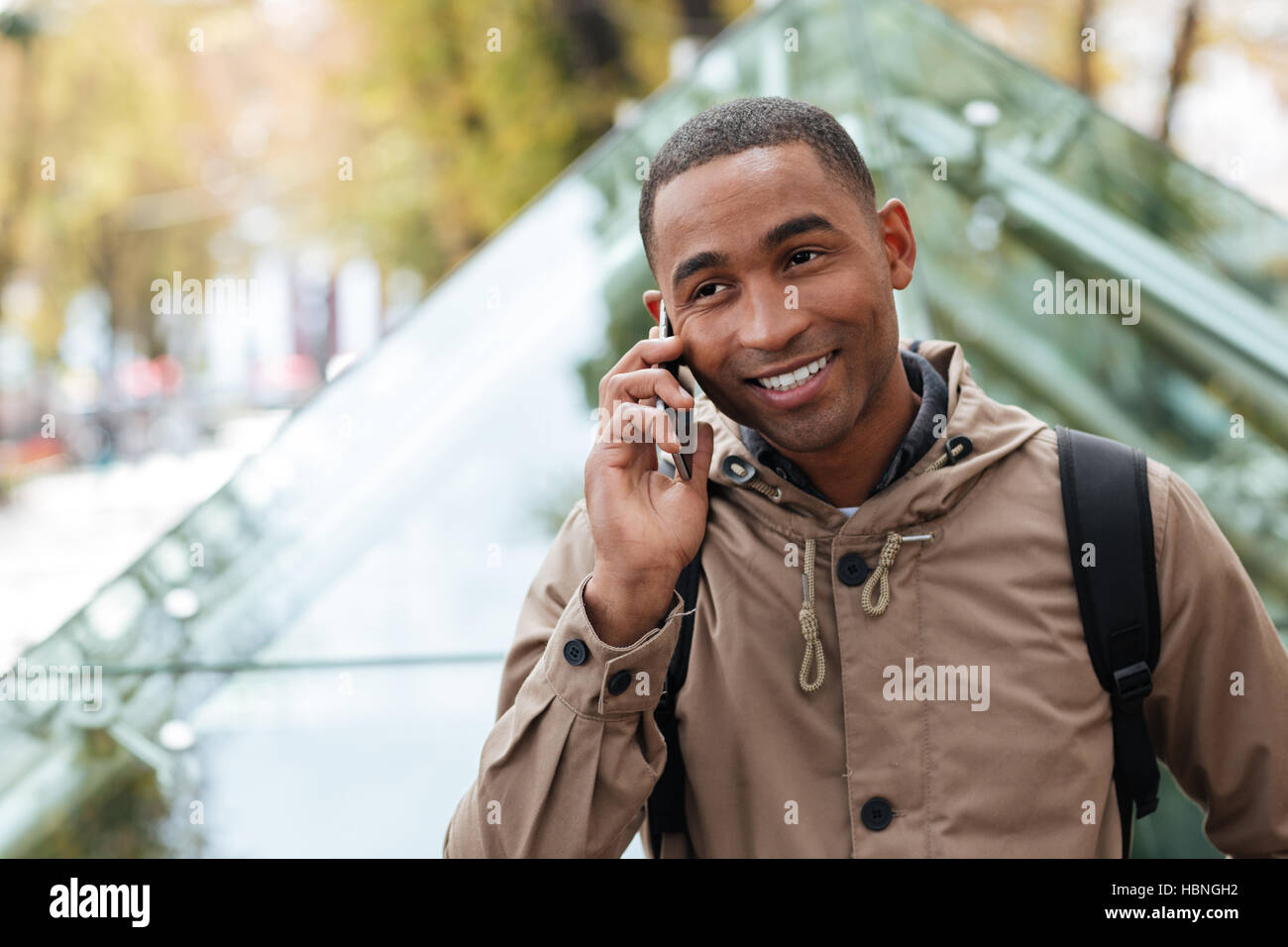Portrait of cheerful young african man talking on his phone on the ...