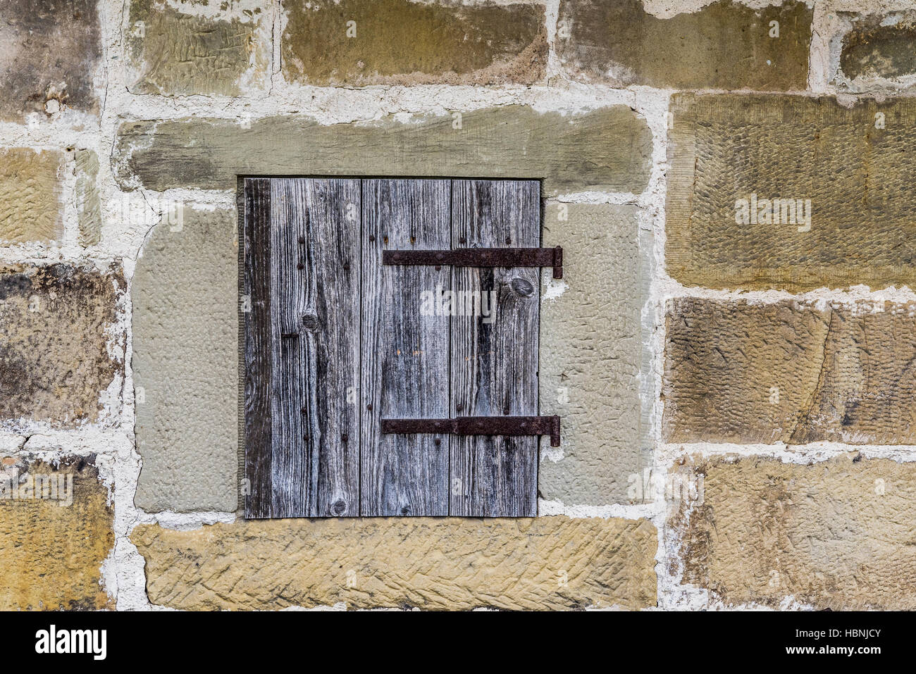 Stone wall with a wooden trapdoor Stock Photo - Alamy