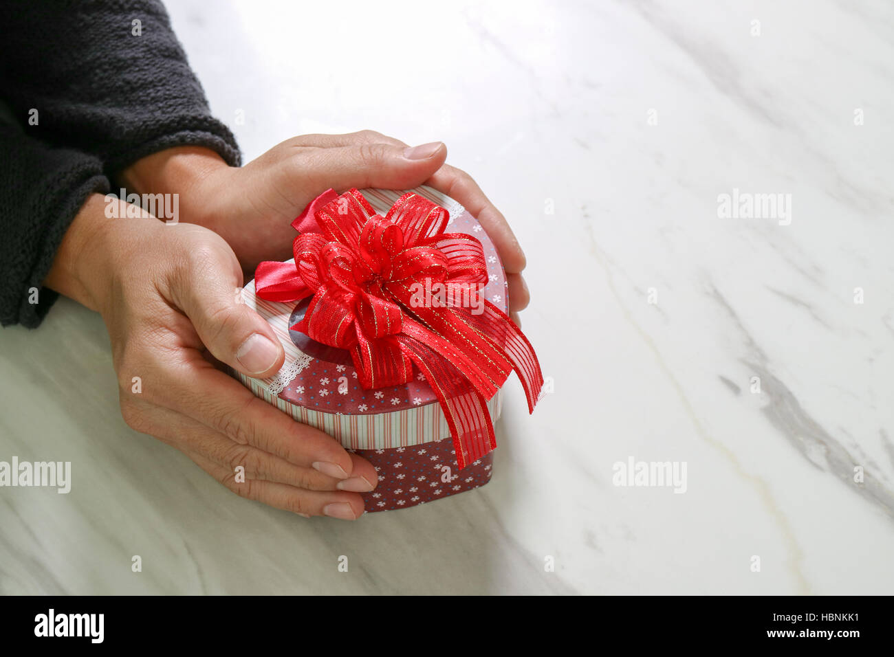 gift giving,man hand holding a heart shape gift box in a gesture of ...