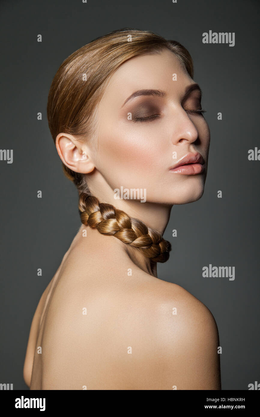 Beautiful young woman with hair around her neck. Vertical studio shot ...