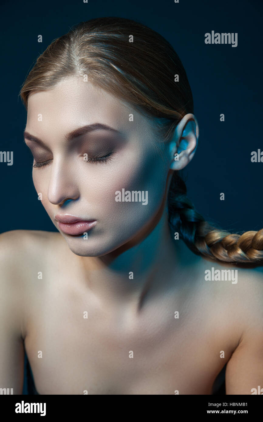 Studio shot of young model keeping eyes closed with cheek and ear ...