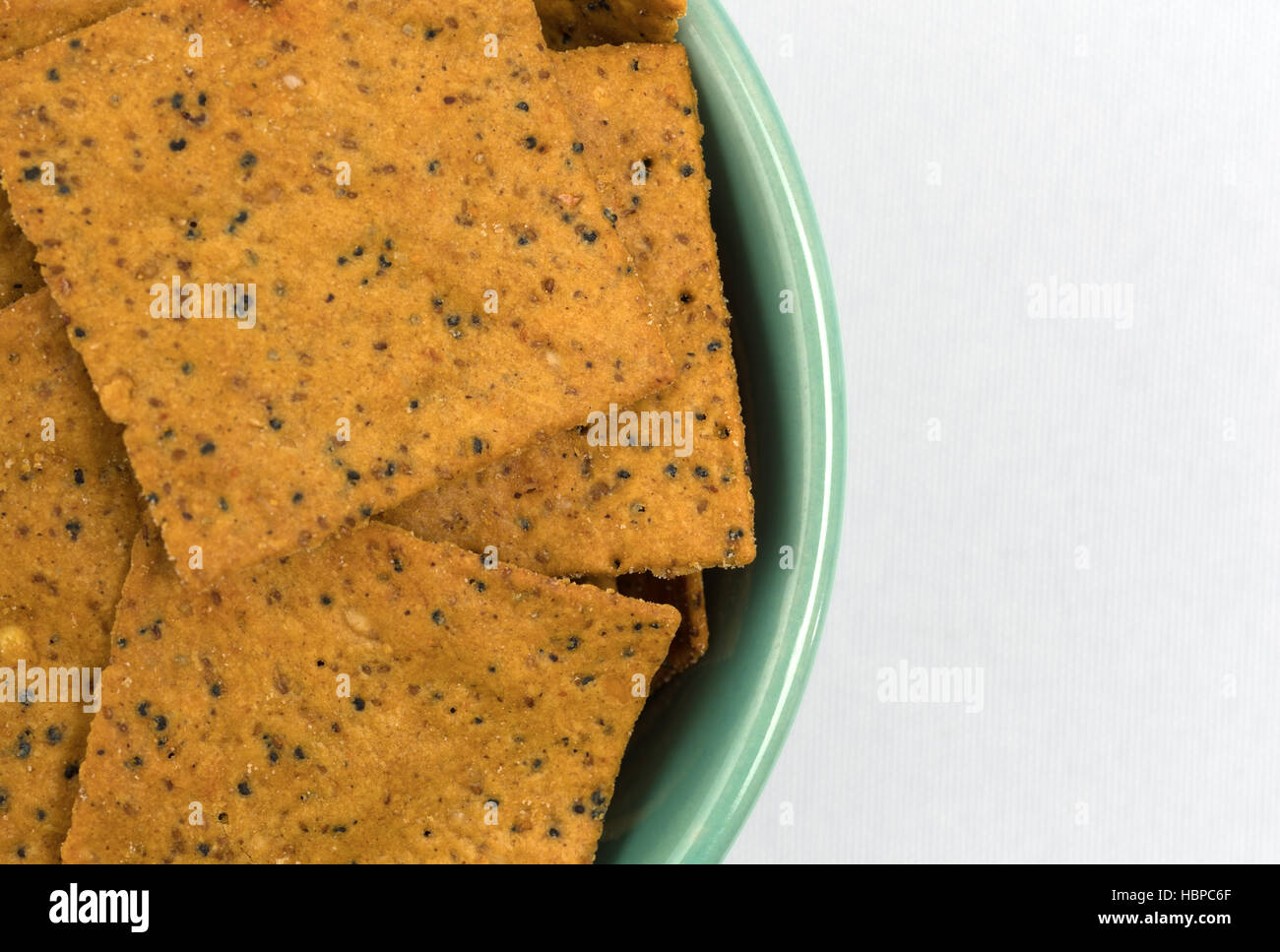 Top close view of gourmet teff whole grain snack crackers in a green ...