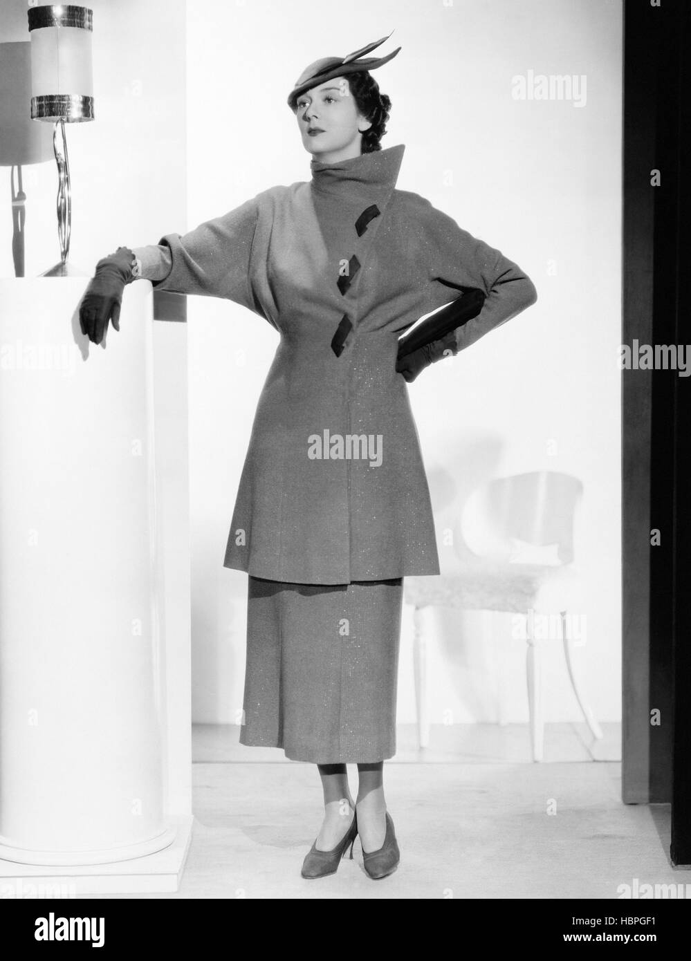 EVELYN PRENTICE, Rosalind Russell, in beige wool suit shot through with ...