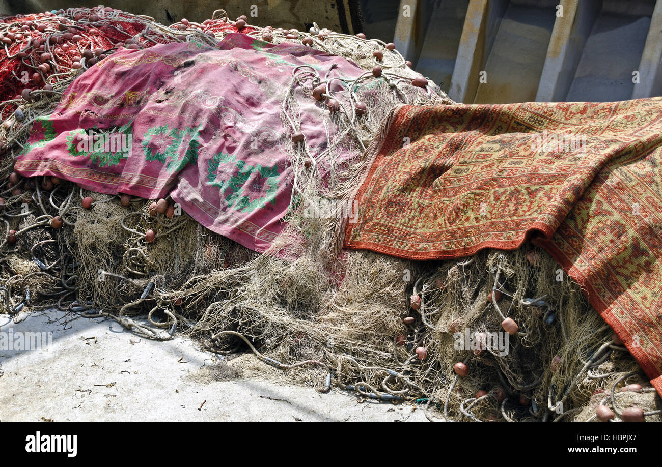 carpets on a stack of fishing nets Stock Photo - Alamy