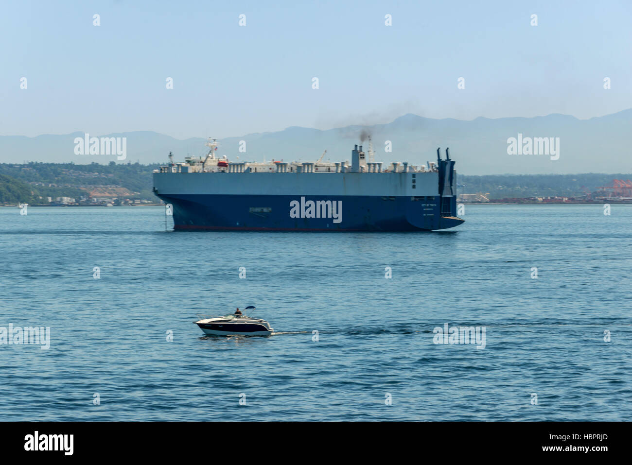 A cargo ship and a small speedboat in the Puget Sound near Seattle ...