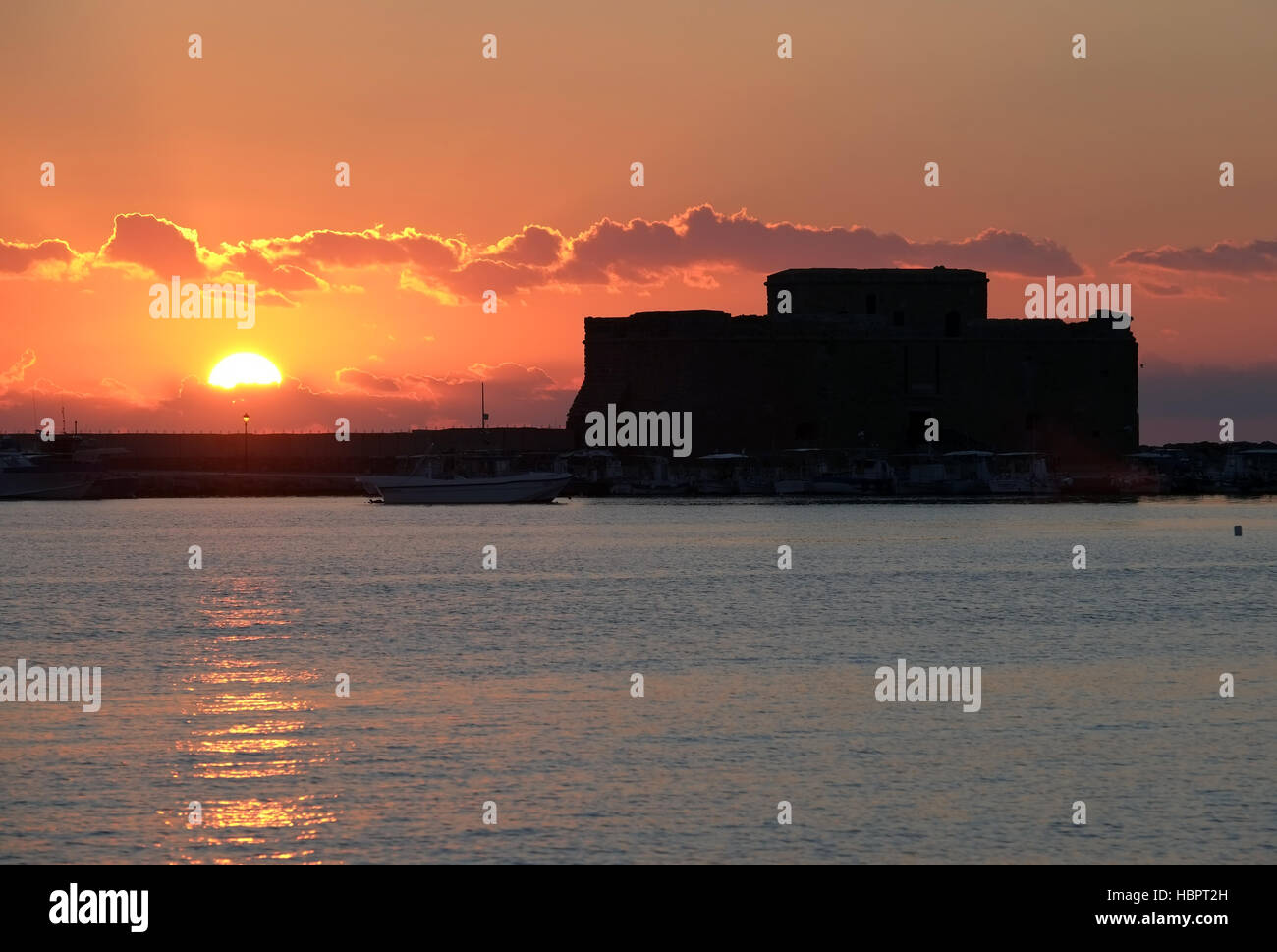 Sunsets behind Paphos Castle or Paphos Fort which is located at the ...